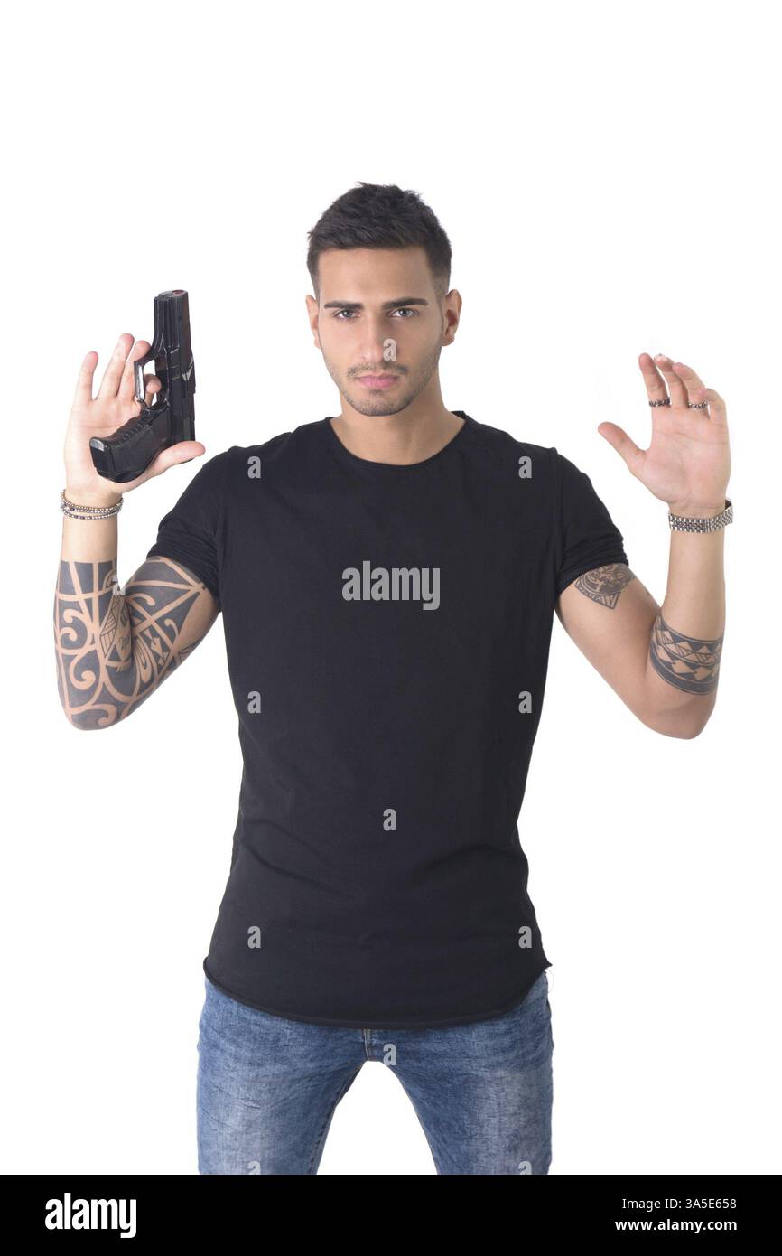 Young handsome man holding gun surrendering, keeping his hands and arms ...