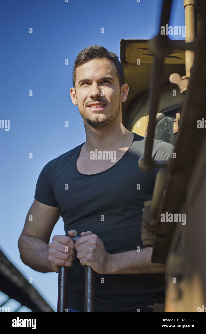 Handsome young man holding from old train handle, looking far Stock ...