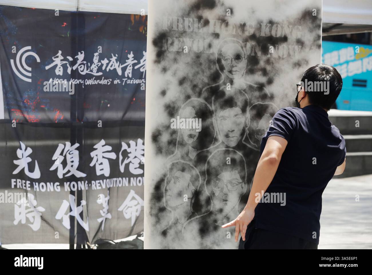 A Hong Kong activist sprays painting of the Hong Kong 47 political ...