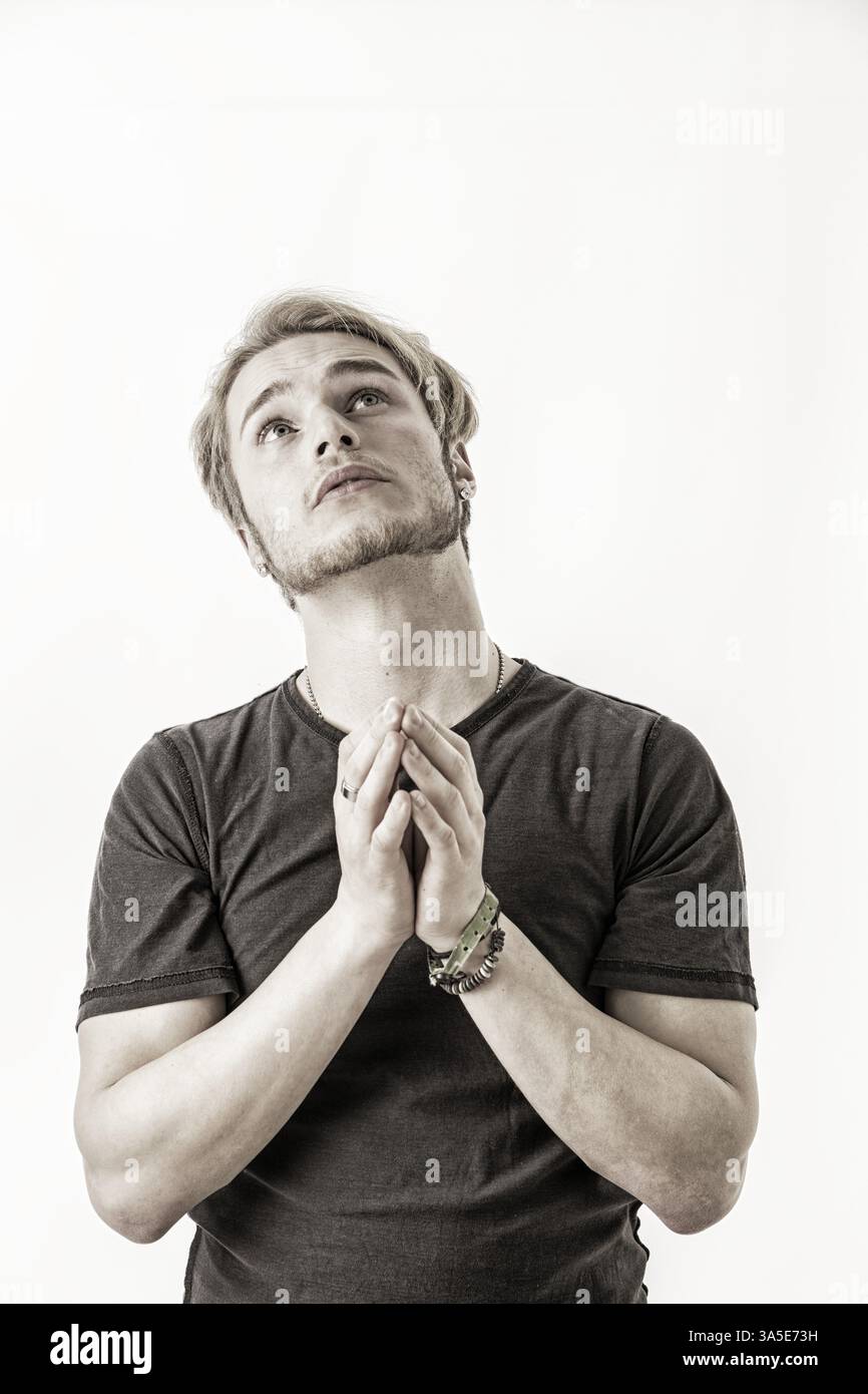 Needy, desperate young man pleading with hands joined as if praying to ...