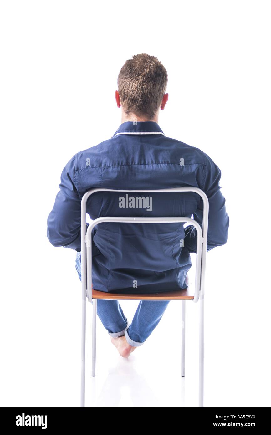 Back of barefoot young man sitting on chair, isolated on white ...