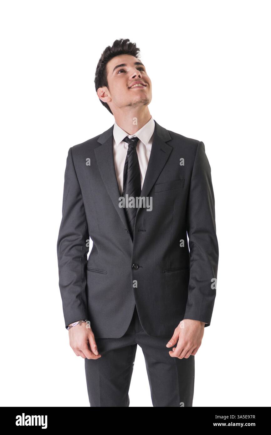 Young businessman confidently posing and looking up smiling, wearing ...