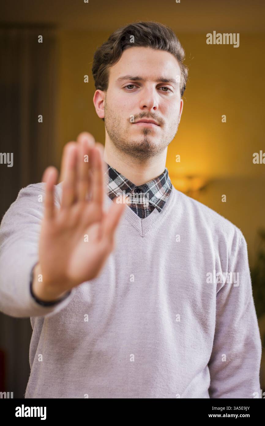 Handsome, seerious young man doing stop sign with his hand with a ...