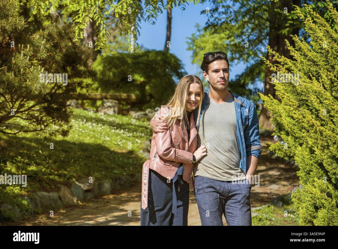 Boyfriend and girlfriend standing in countryside in green luscious ...