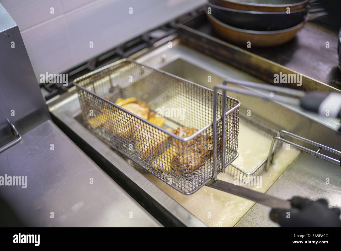 Metal basket filled with crispy samosas and golden potato wedges ...