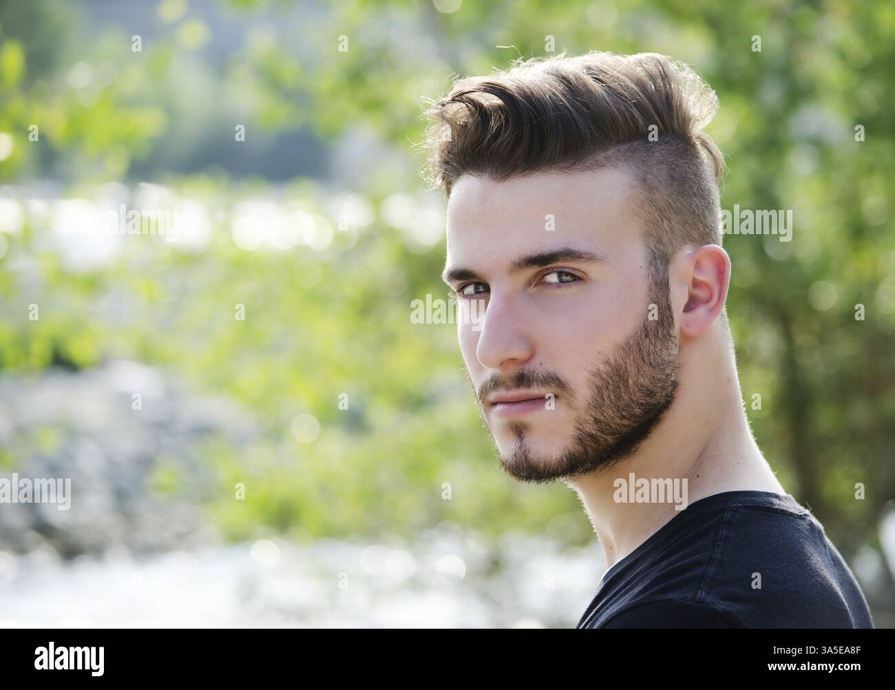Portrait of attractive young man outdoors, looking in camera Stock ...