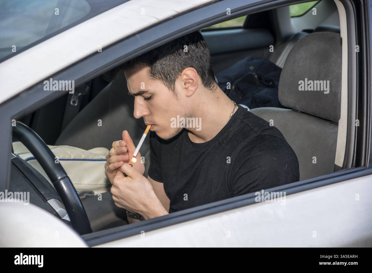 Handsome Young Man smoking cigarette while Driving a Car Stock Photo ...