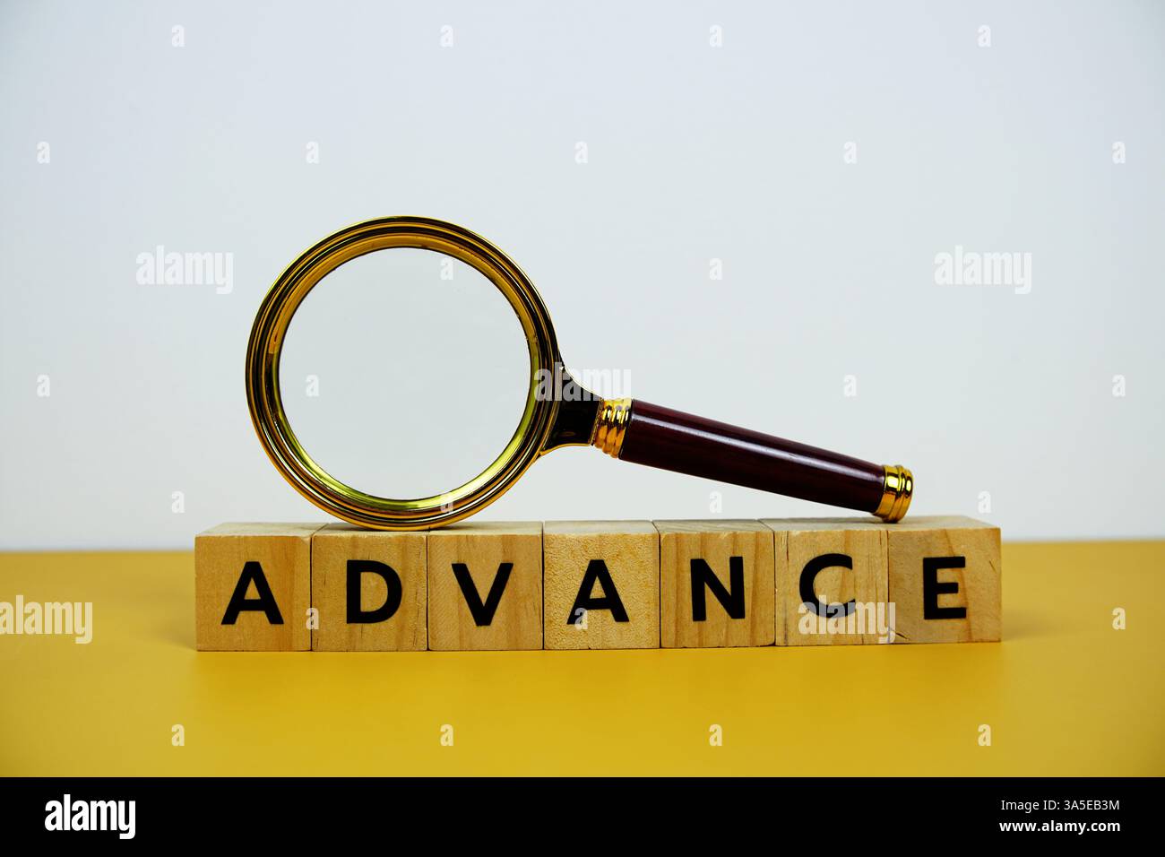Magnifying glass with wooden blocks alphabet letters ADVANCE text ...
