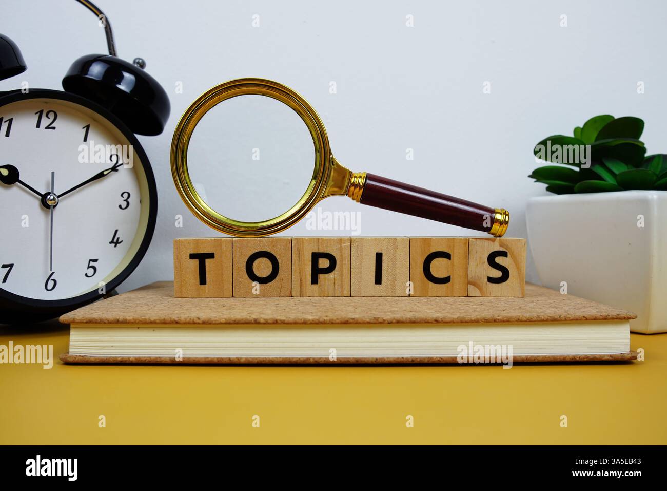 Magnifying glass and alarm clock with wooden blocks alphabet letters ...