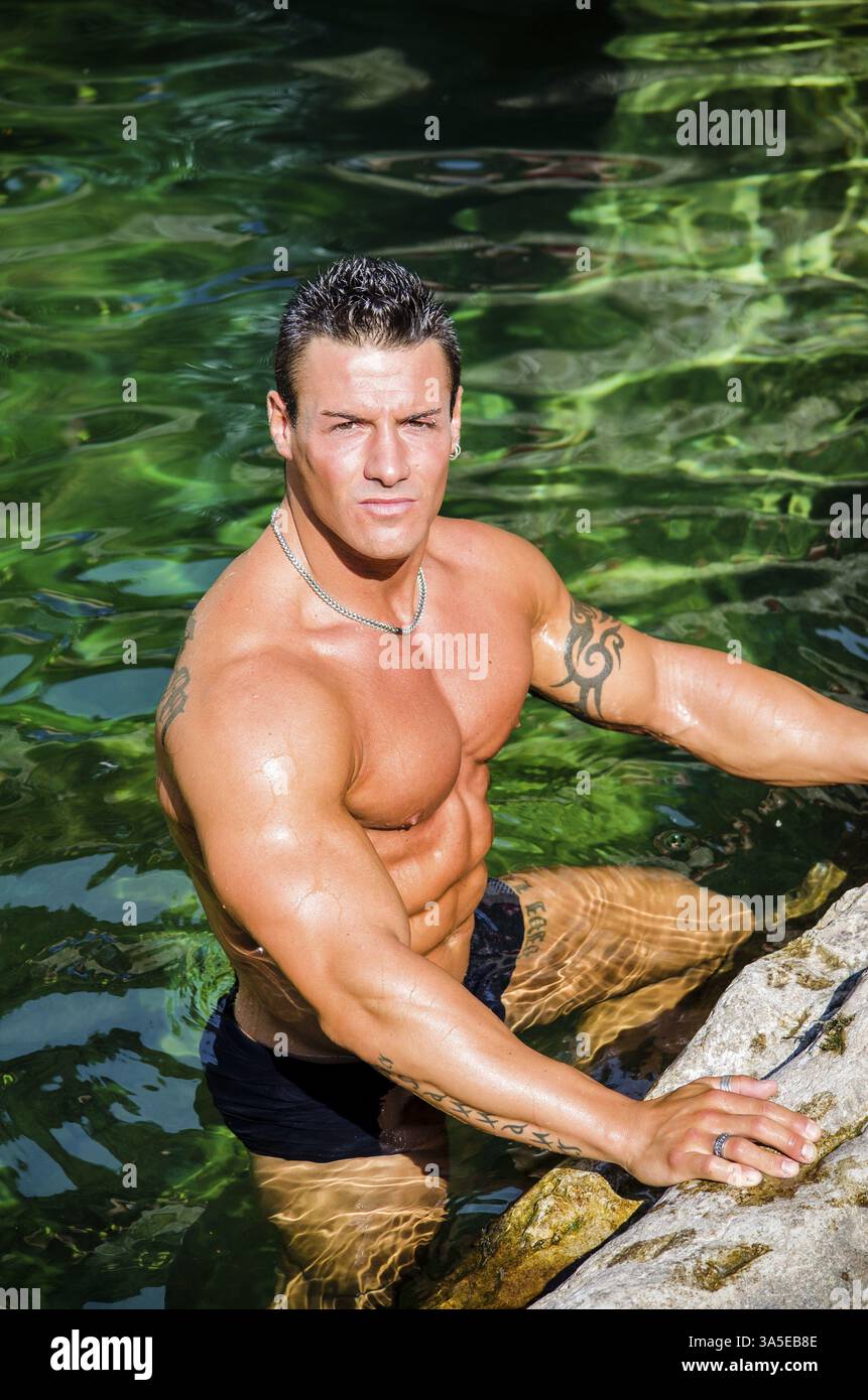 Handsome young muscle man standing in water pond or river Stock Photo ...