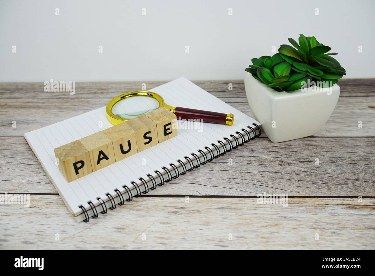 Magnifying glass with wooden blocks alphabet letters PAUSE text message ...