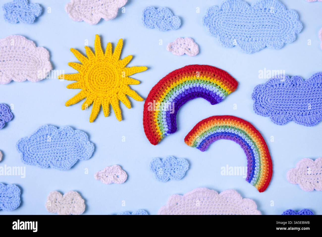 Knitted toys blue and white clouds, yellow sun, rainbow on blue ...