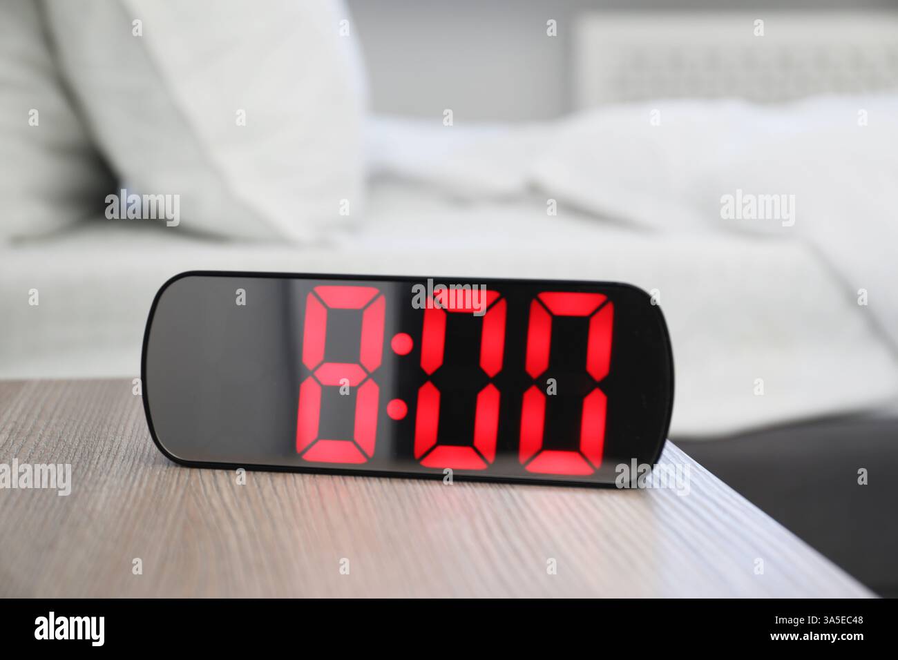 Digital alarm clock showing 8:00 o'clock on bedside table indoors Stock ...