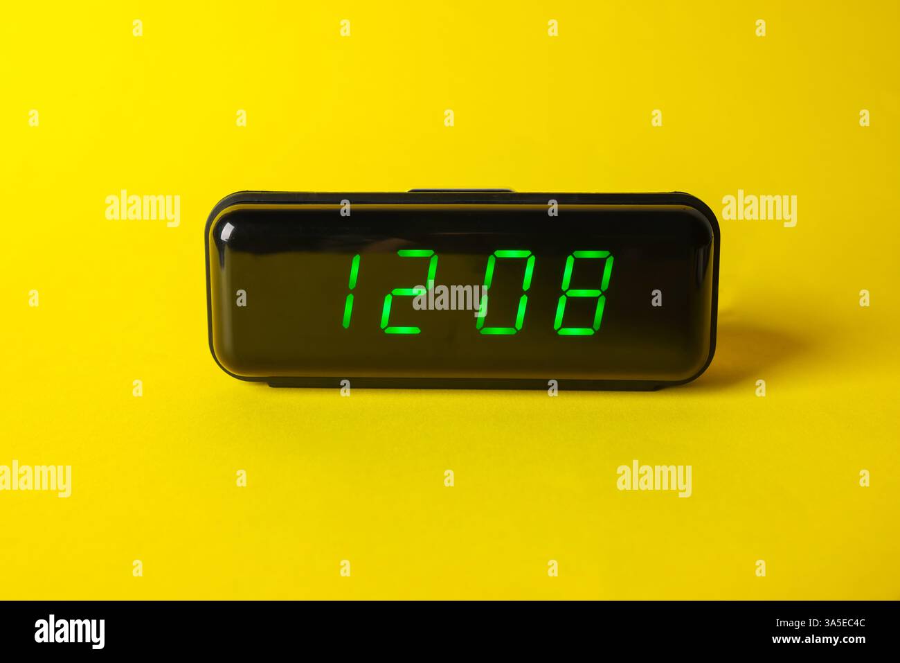 Digital alarm clock showing 12:08 o'clock on yellow background Stock ...
