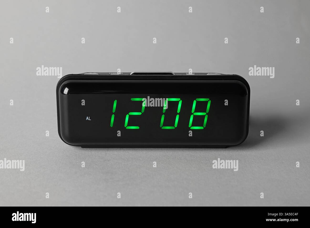 Digital alarm clock showing 12:08 o'clock on grey background Stock ...