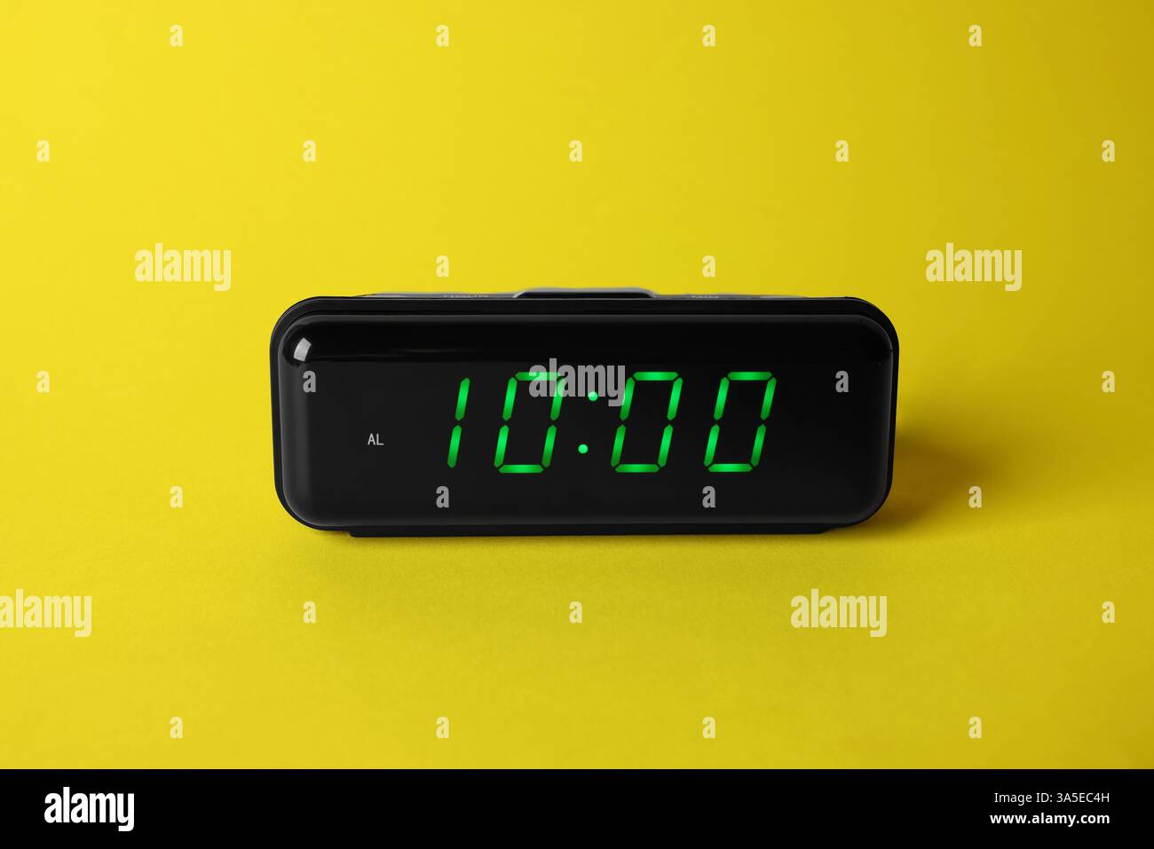 Digital alarm clock showing 10:00 o'clock on yellow background Stock ...