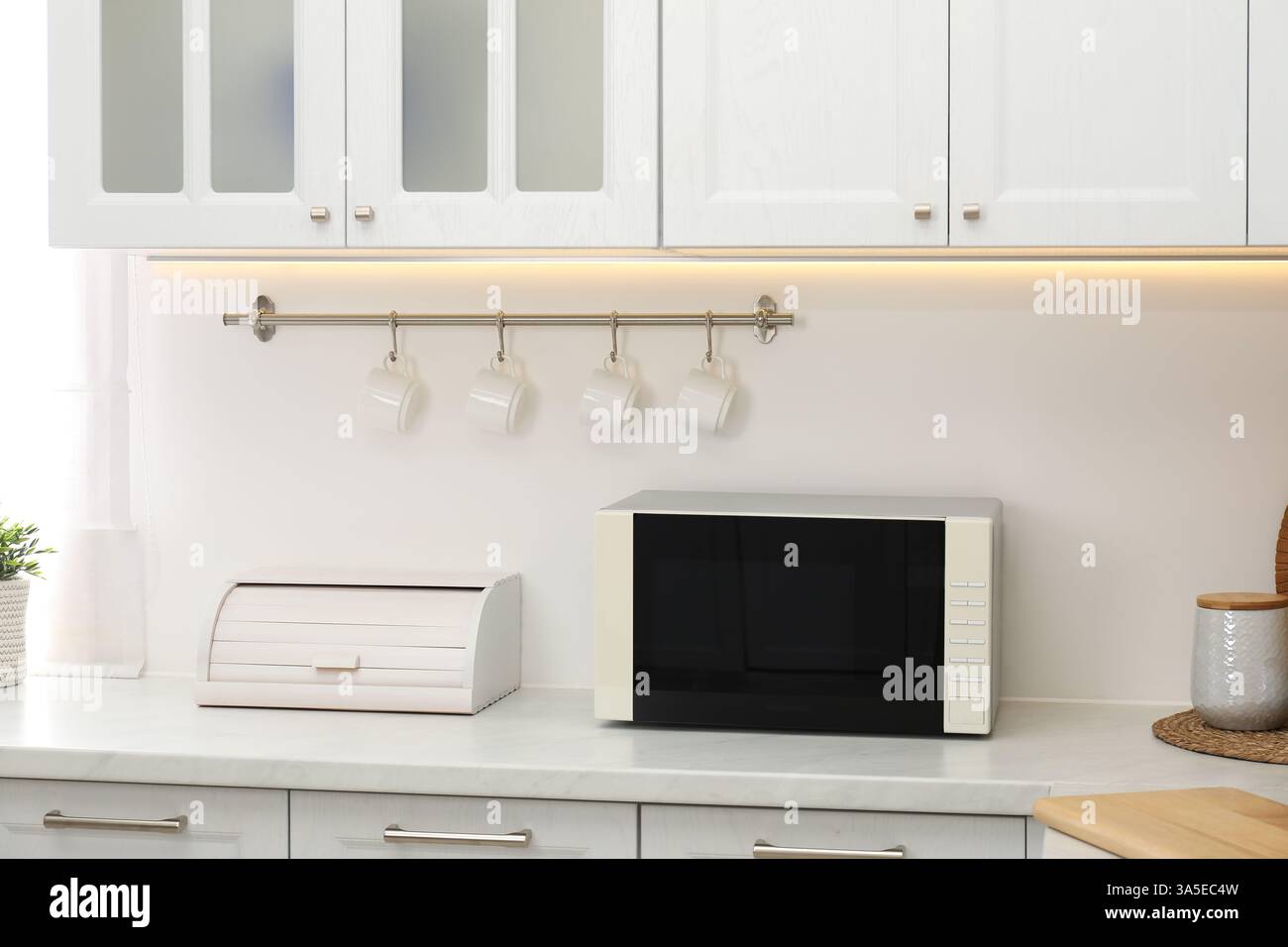 Closed microwave oven on counter in kitchen Stock Photo - Alamy