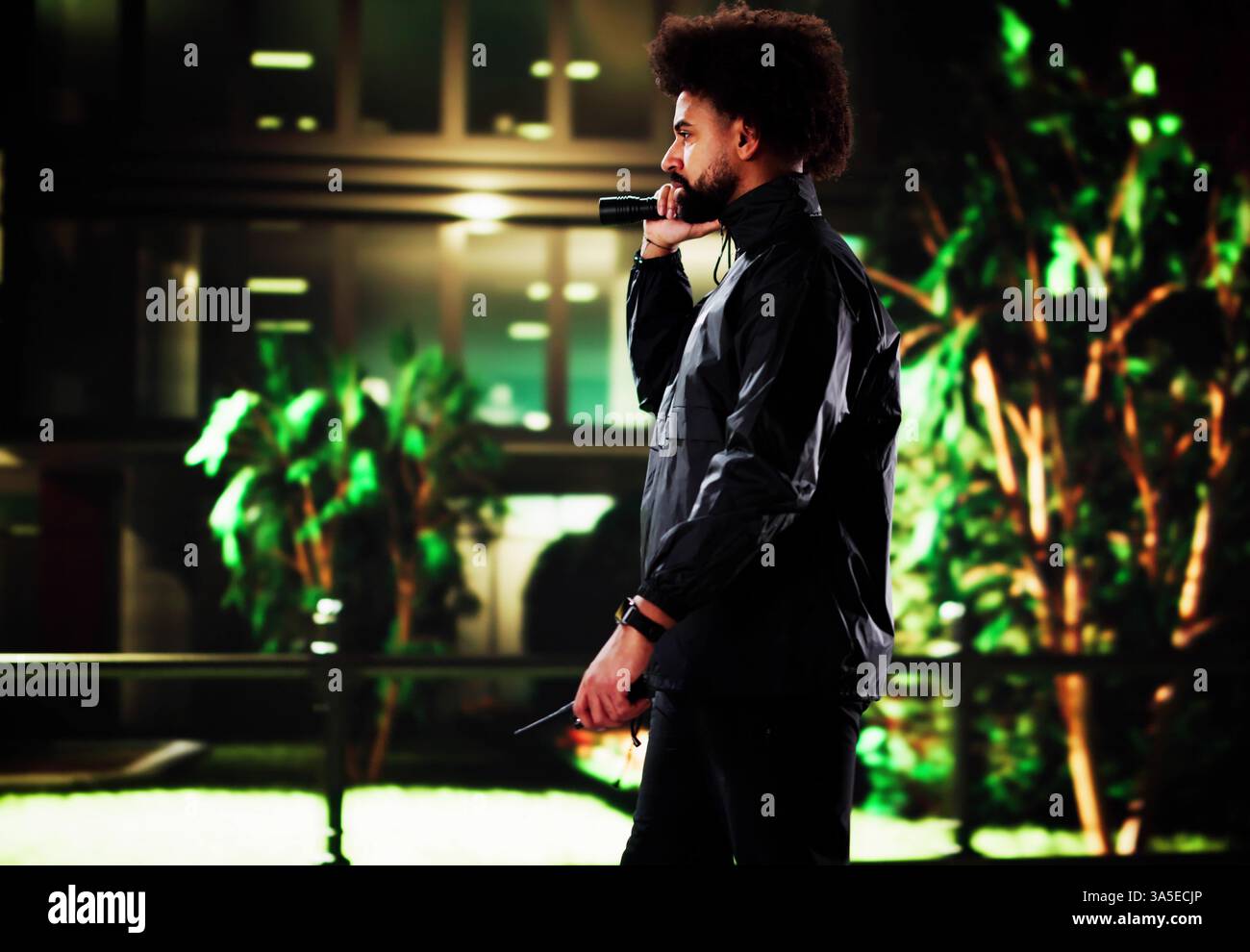 Nighttime Security Guard Patrolling Building Perimeter with Flashlight ...