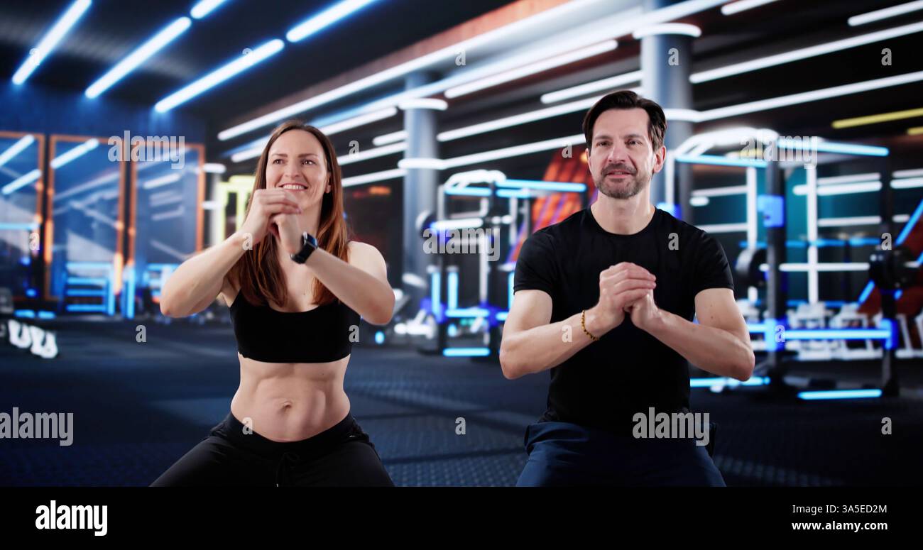 Female athlete challenges personal trainer with squats in gym class ...
