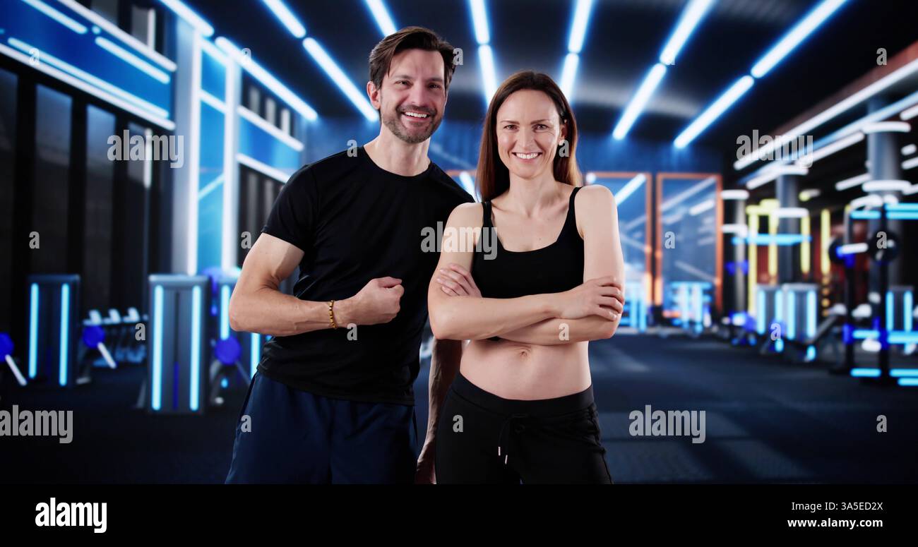 Fitness coach trains young couple in gym, showing off biceps Stock ...