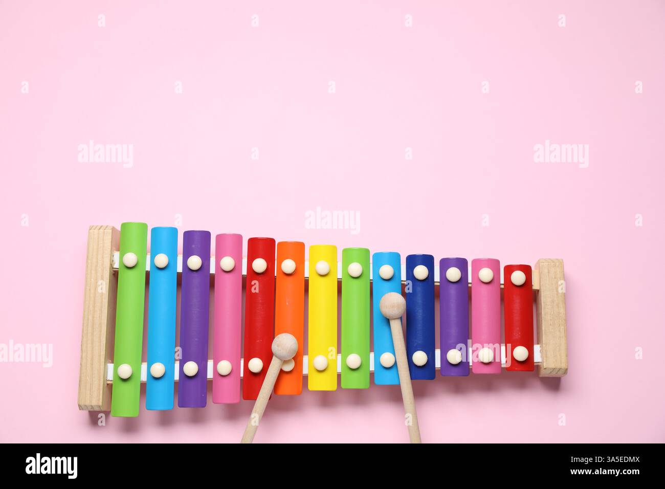 Colorful toy xylophone with mallets on pink background, top view. Space for text Stock Photo - Alamy