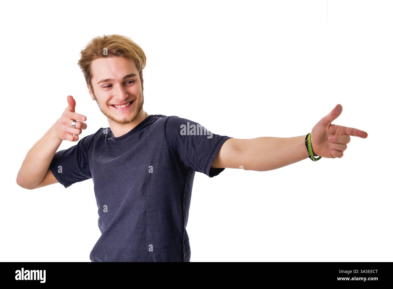 Smiling young man pointing fingers. Studio shot, isolated Stock Photo ...