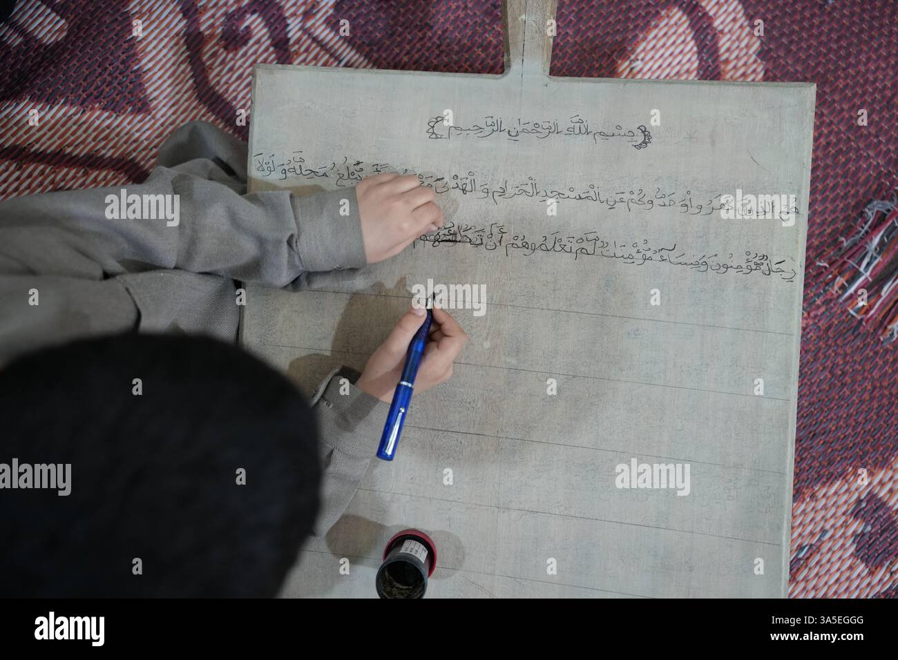A six-year-old student, one of the youngest in the class, sits quietly ...