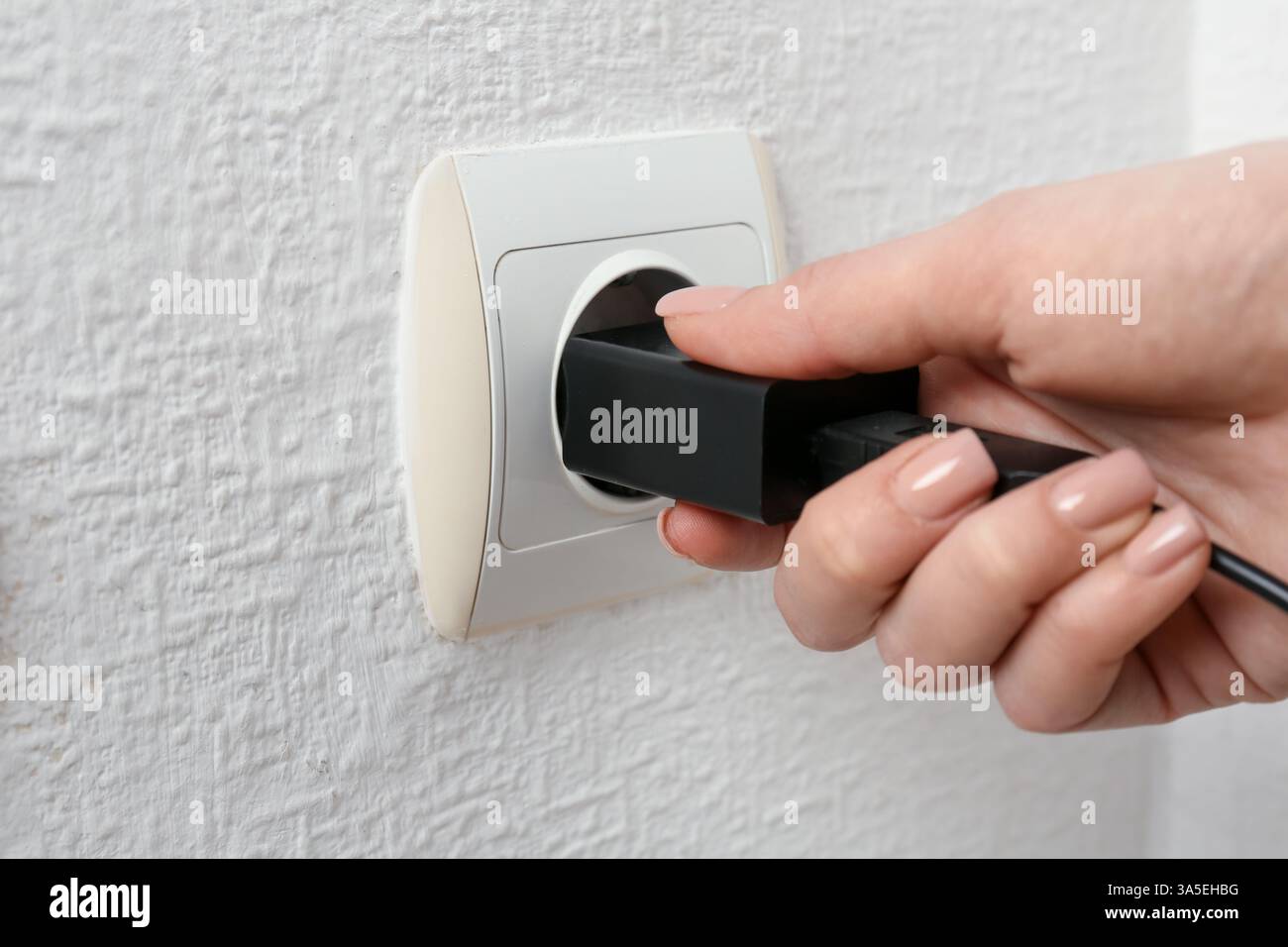 Woman plugging USB power adapter with charge cable into electrical ...