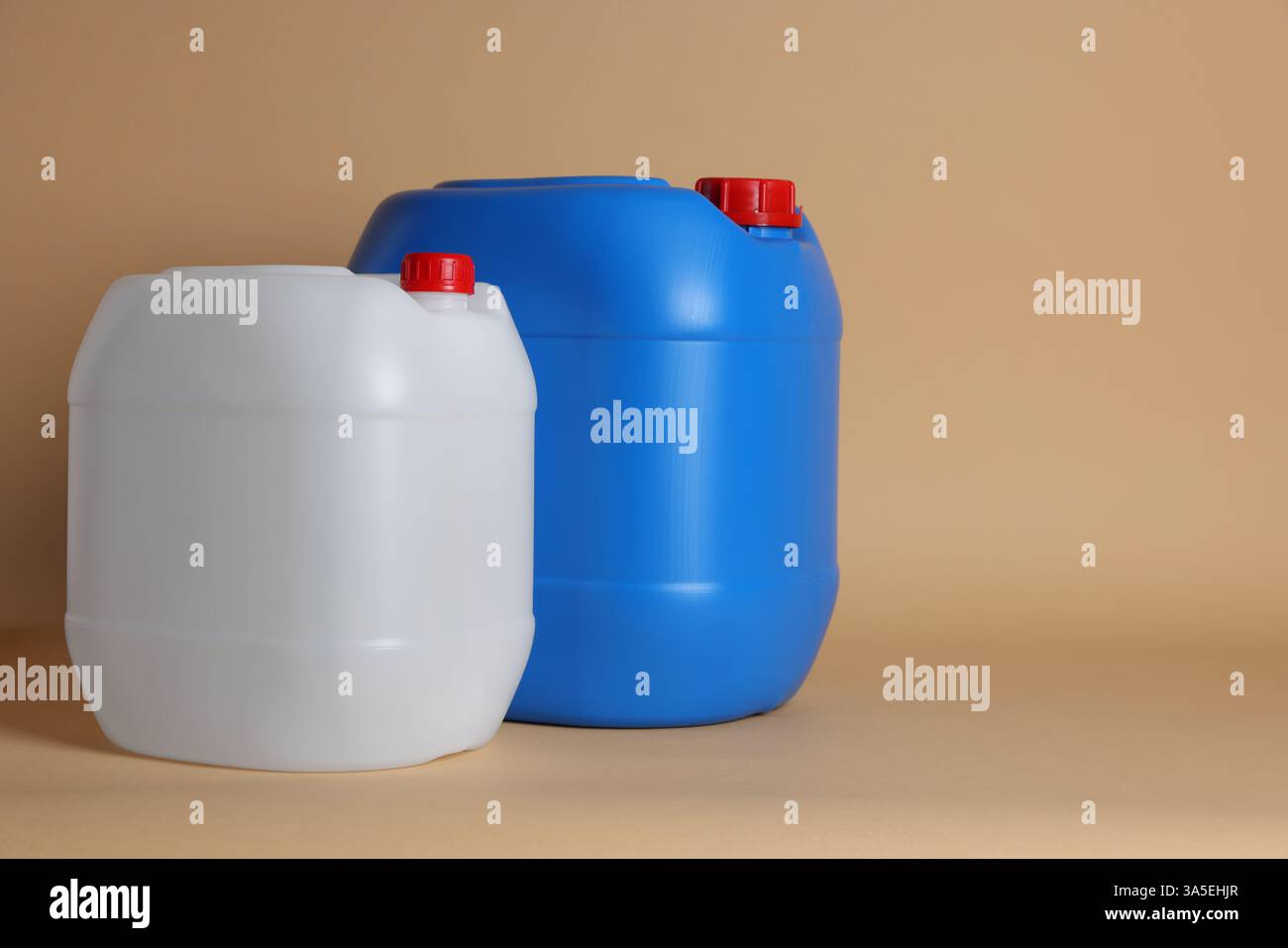 Two clean plastic canisters on beige background Stock Photo - Alamy