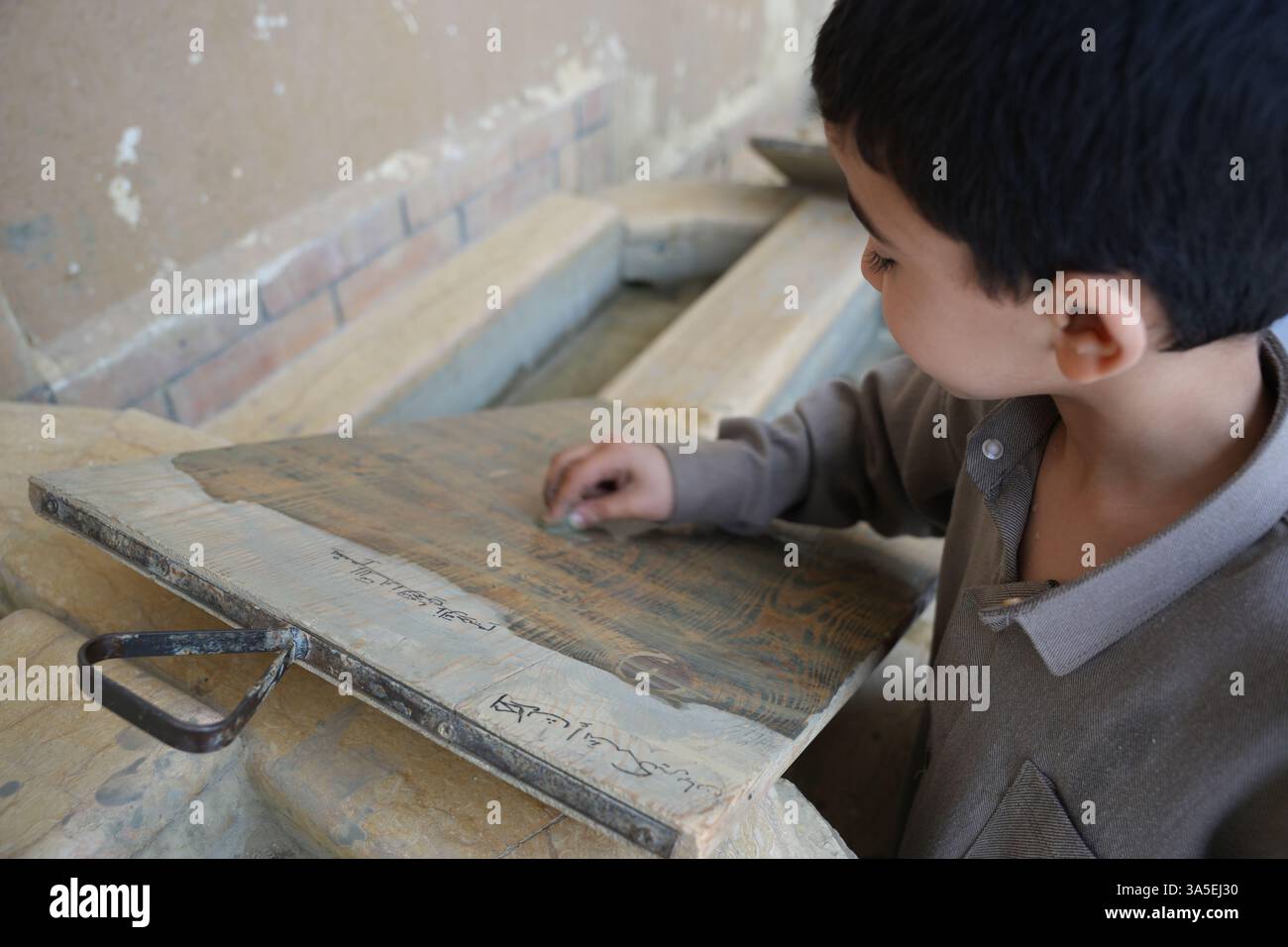 Misrata, Libya. 23rd Mar, 2025. Students clean their wooden tablets ...