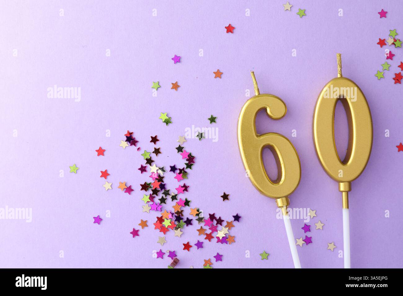 60th birthday. Number shaped candles and confetti on violet background ...