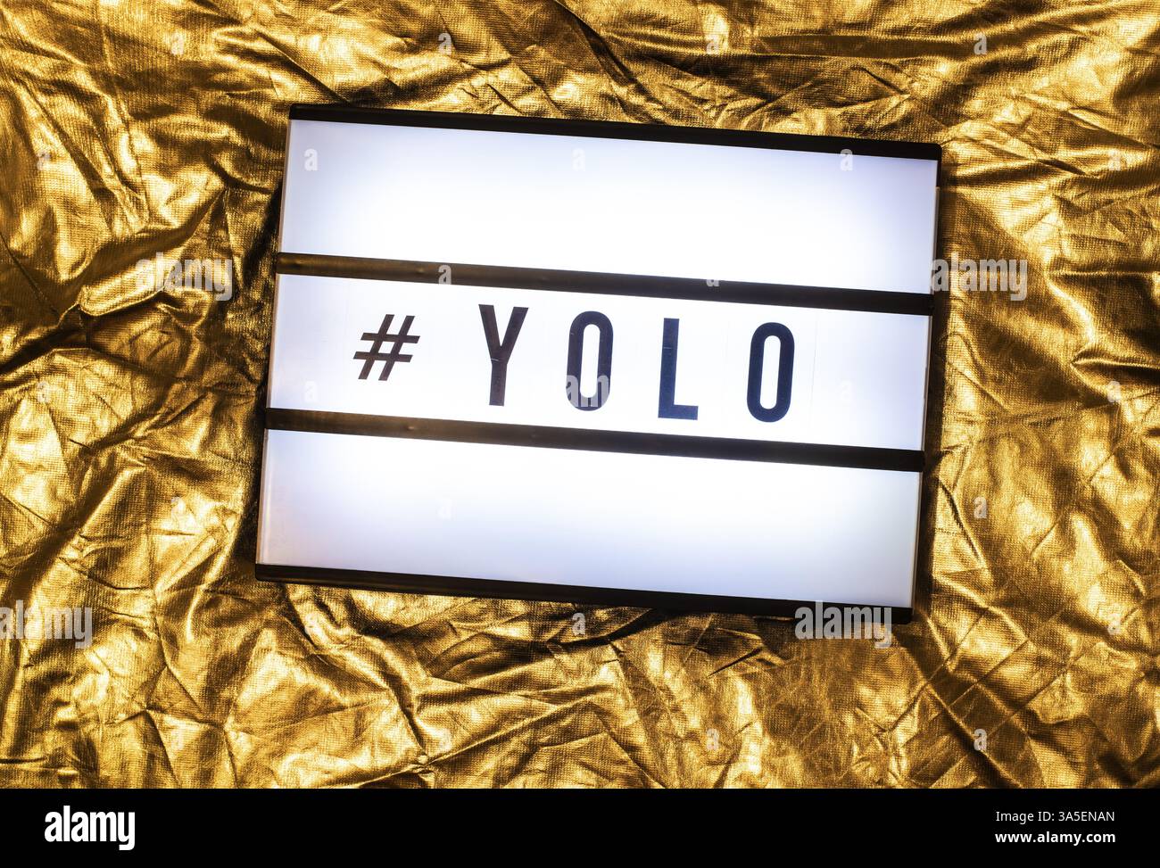 Text YOLO on white illuminated board. You only live once concept and ...