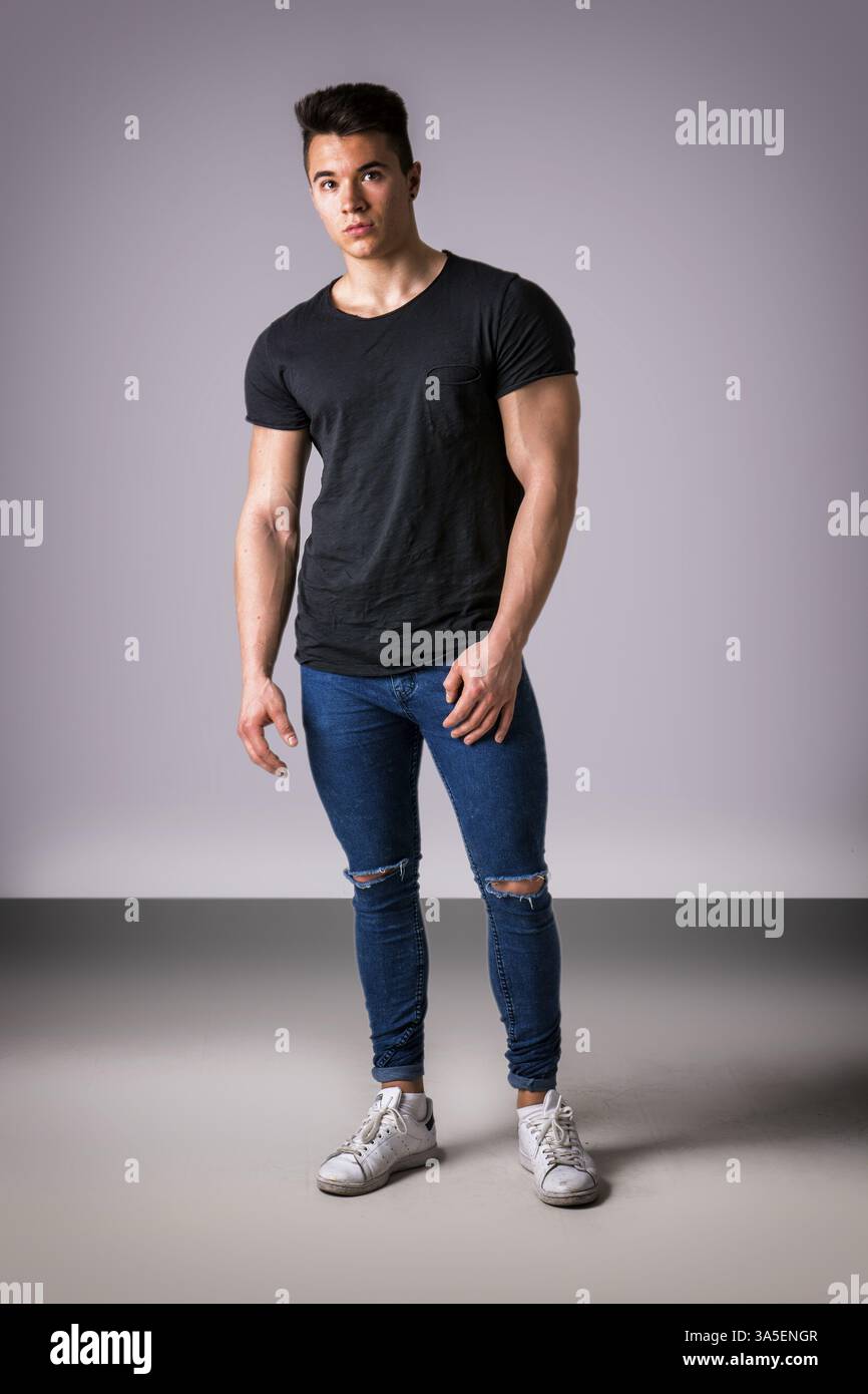 Handsome young muscular man looking at camera in studio shot over ...