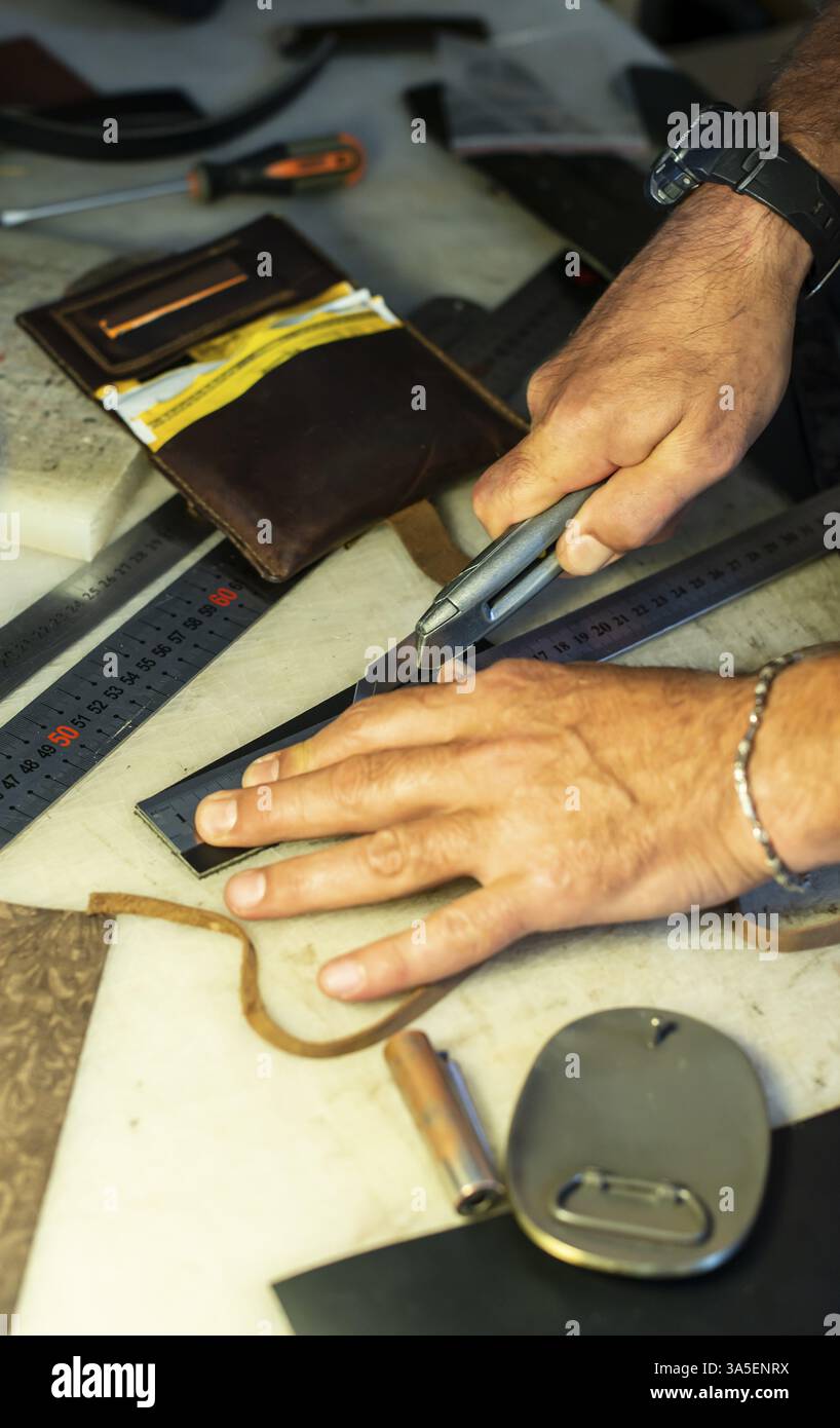 Tailor process leather in workshop. Making leather products Stock Photo ...