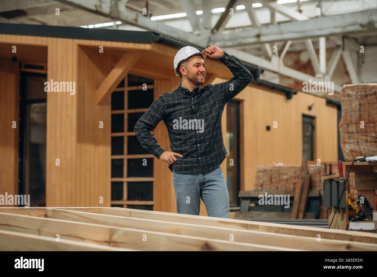 Looks far away. Male builder is at construction of wooden house Stock ...