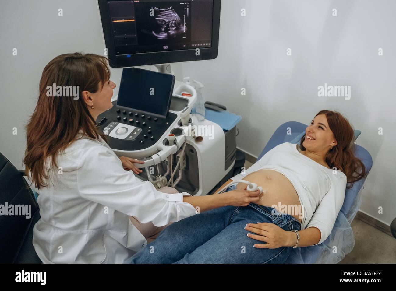 Monitor with graphical representation of scan. Pregnant woman ...