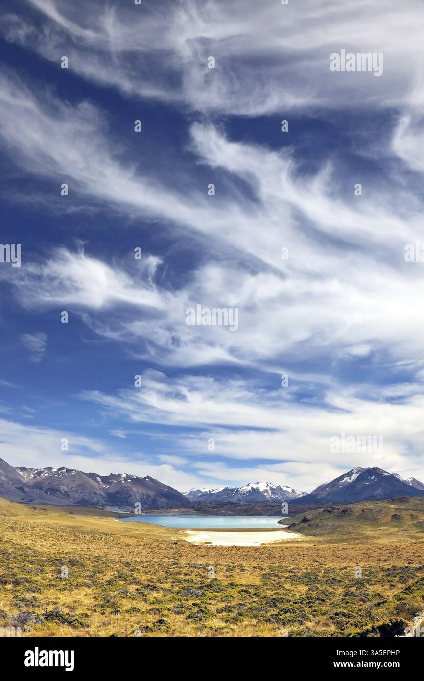 Strong wind turns the clouds in a valley surrounded by snow-capped ...