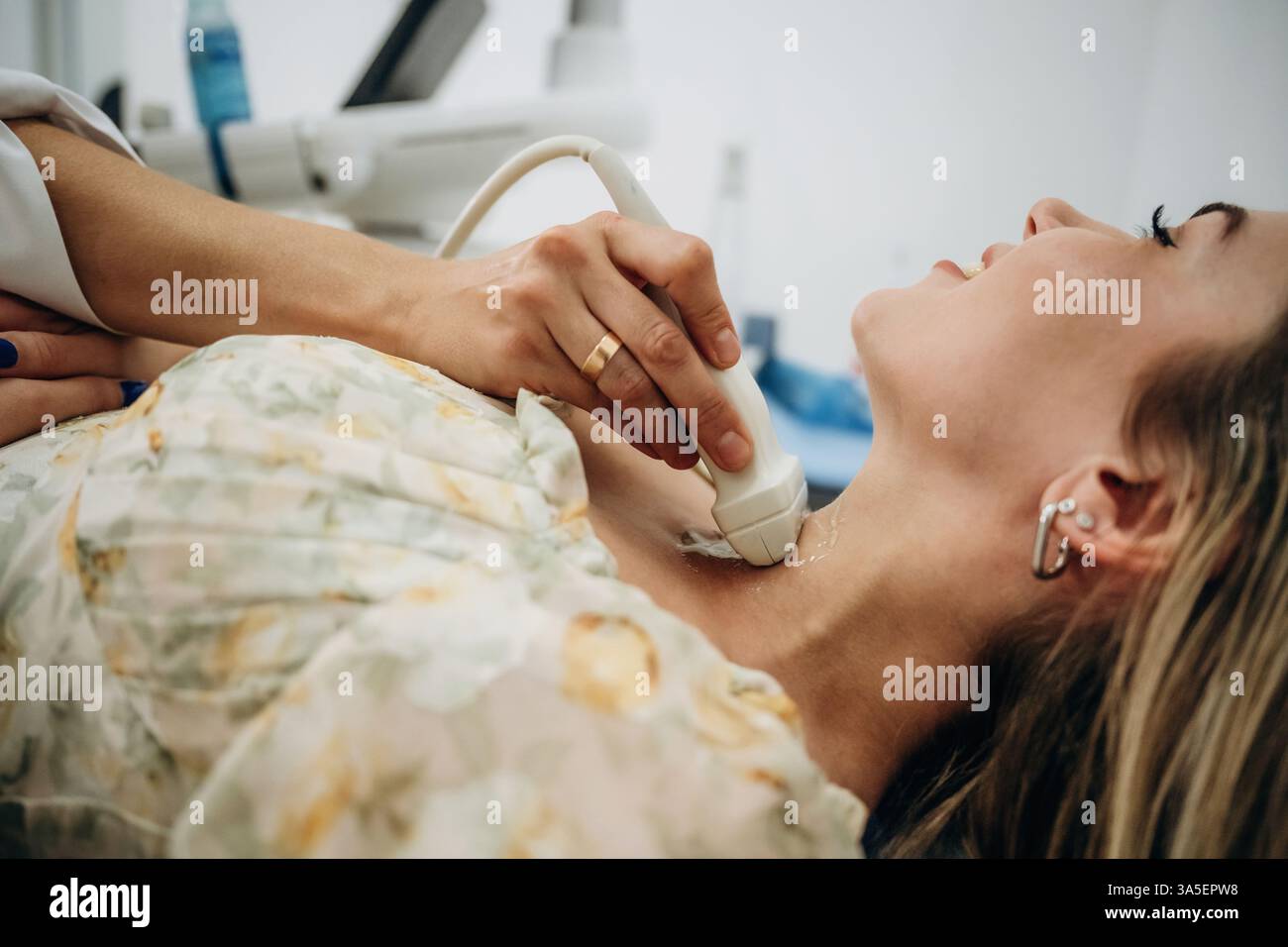 Side view. Woman is lying down and undergoing ultrasonic test of the ...