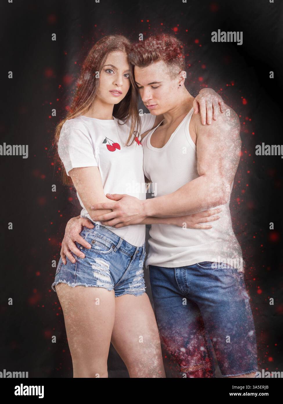 Romantic couple embracing in studio shot, man is muscular, woman is ...