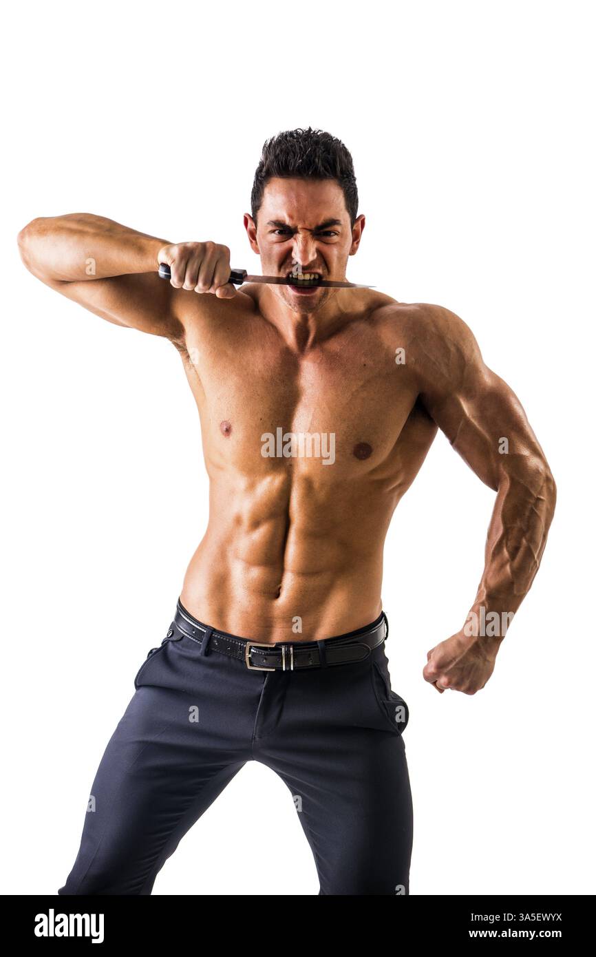 Muscular young man holding big knife biting its blade, isolated on ...