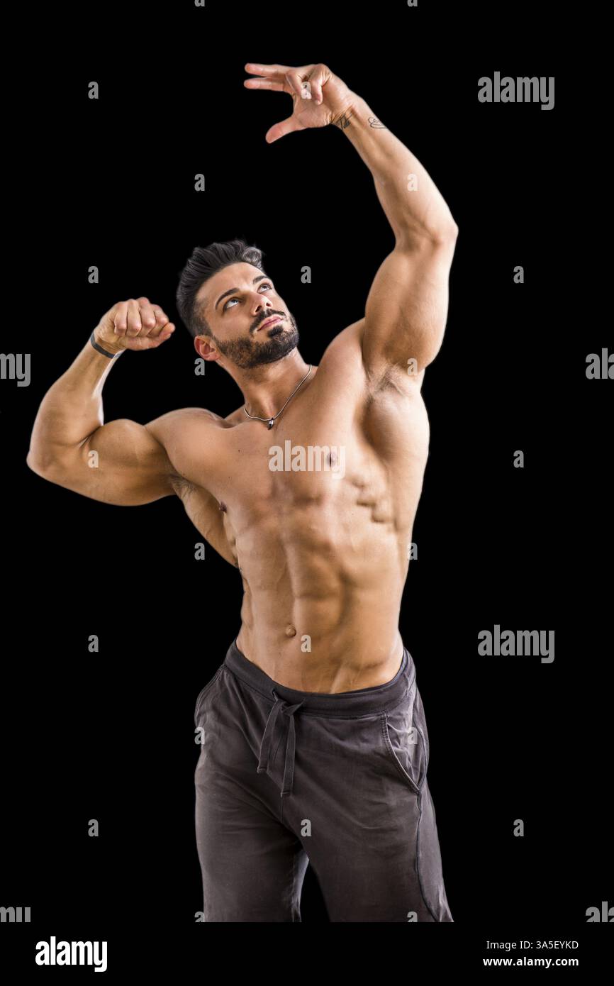Handsome bodybuilder doing classic double biceps pose, looking away ...