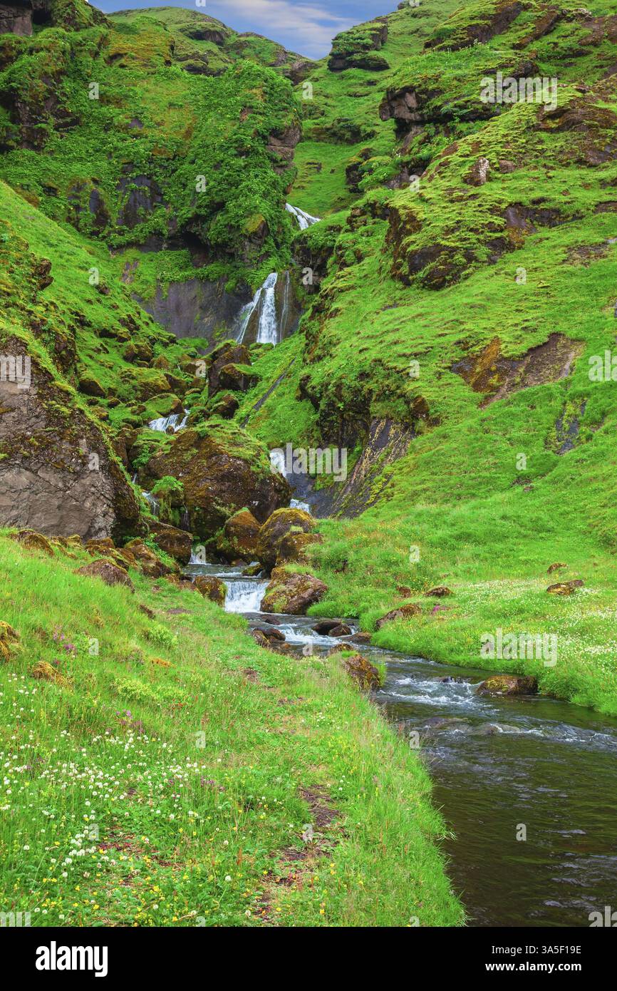 July in Iceland. Picturesque cascade multi-stage waterfall. Mountains ...