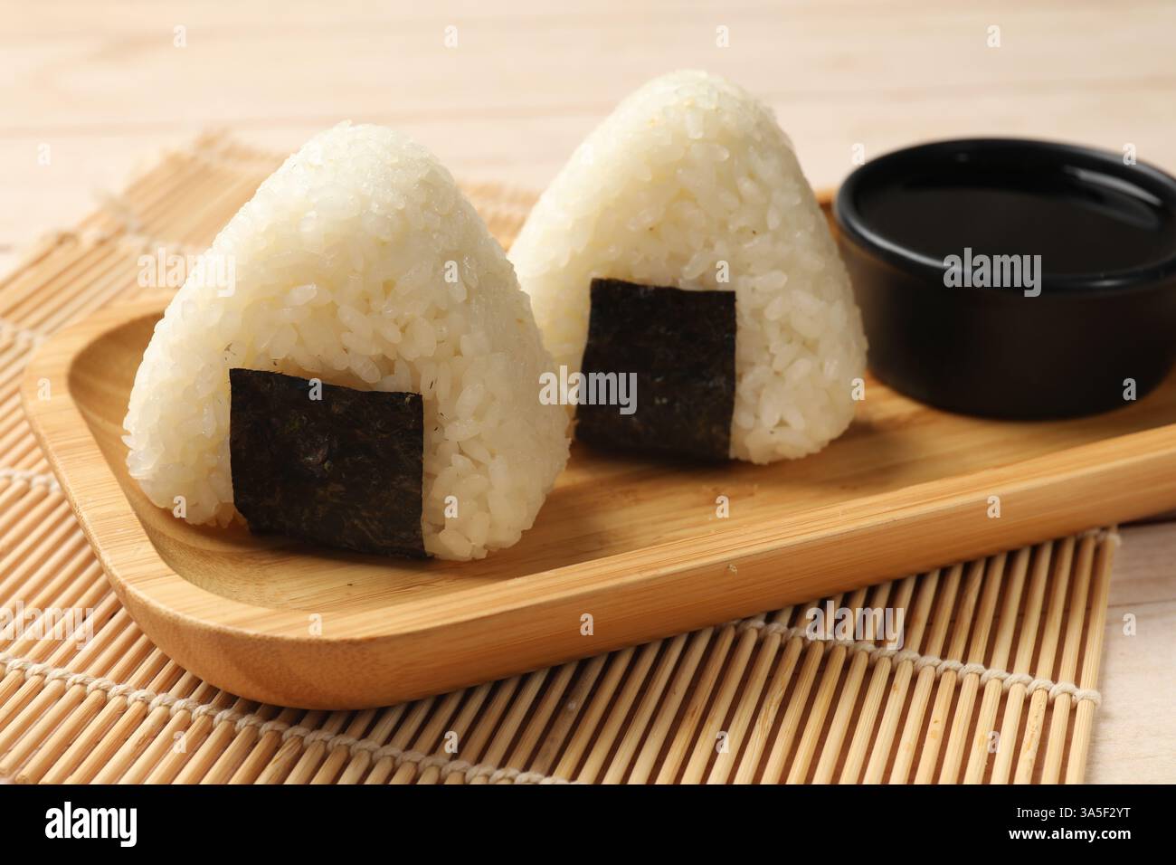 Rice balls (onigiri) and soy sauce on table, closeup. Traditional ...