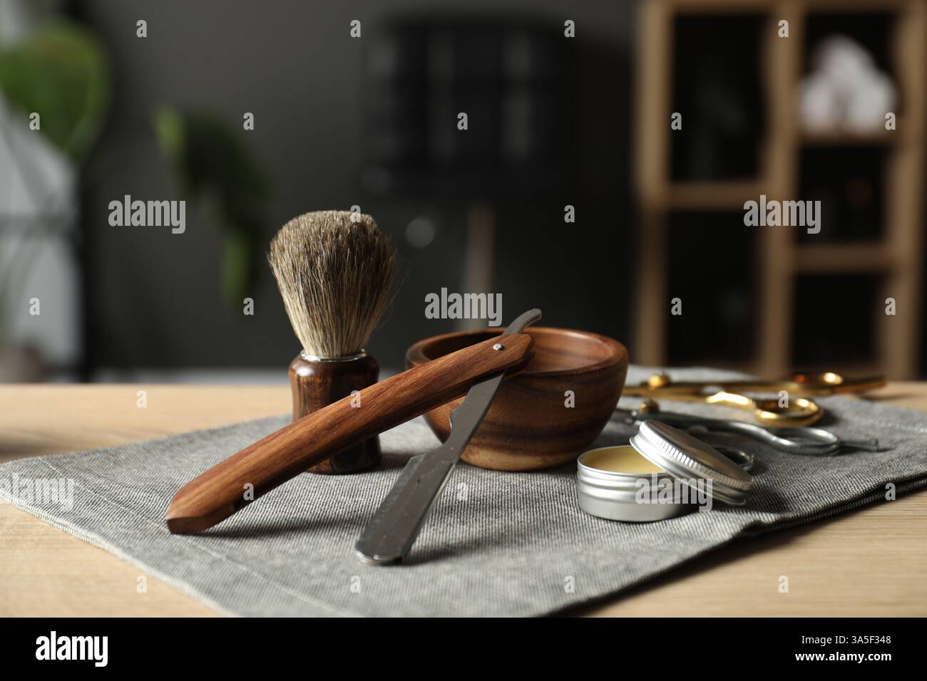 Many different barber's tools on light wooden table in barbershop ...