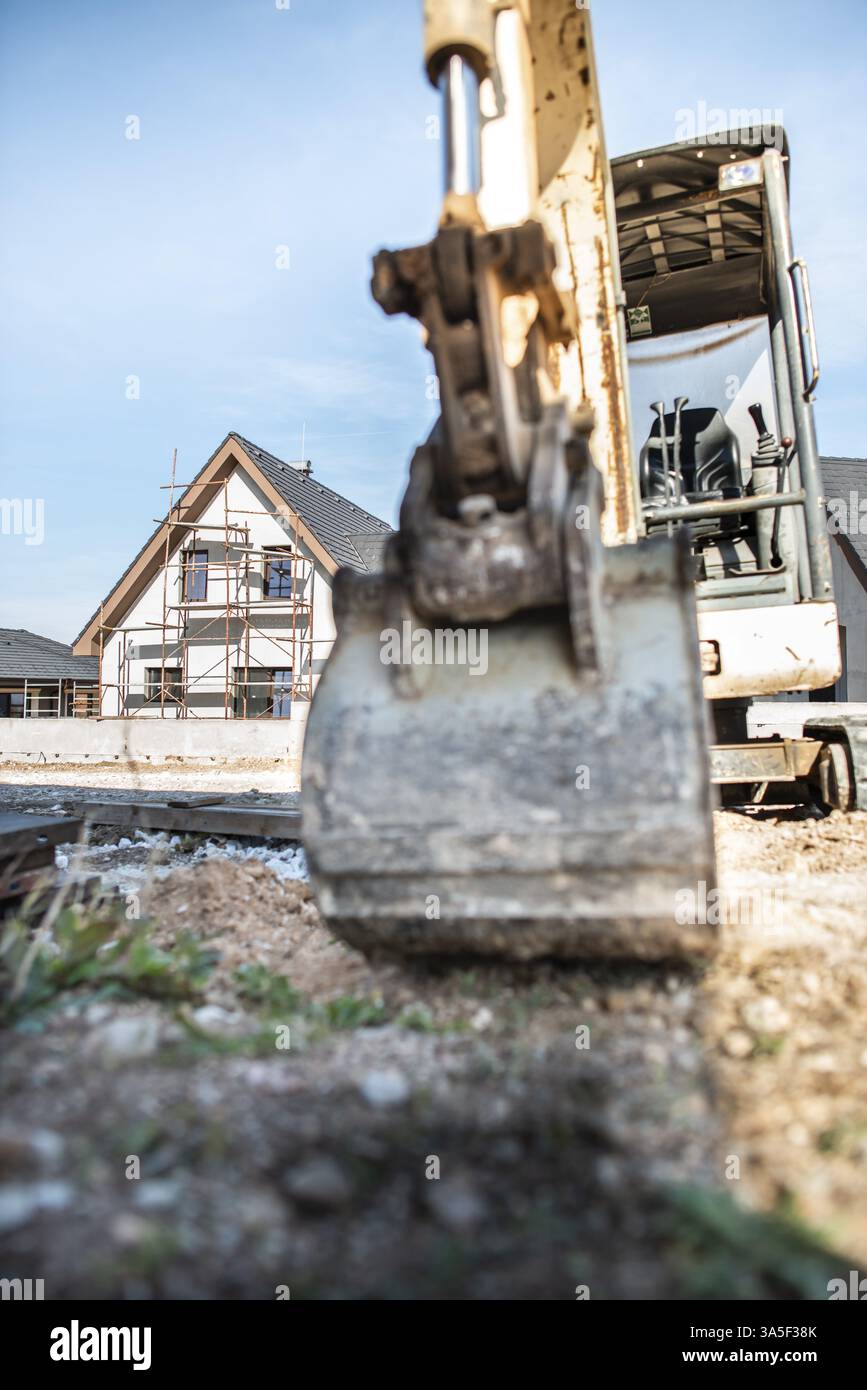 Excavator and newly built houses on construction site Stock Photo - Alamy