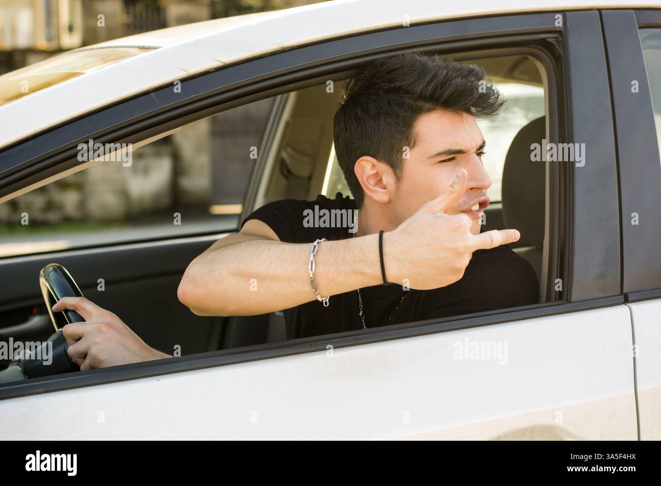 Handsome Young Man Driving a Car and showing the middle finger to ...