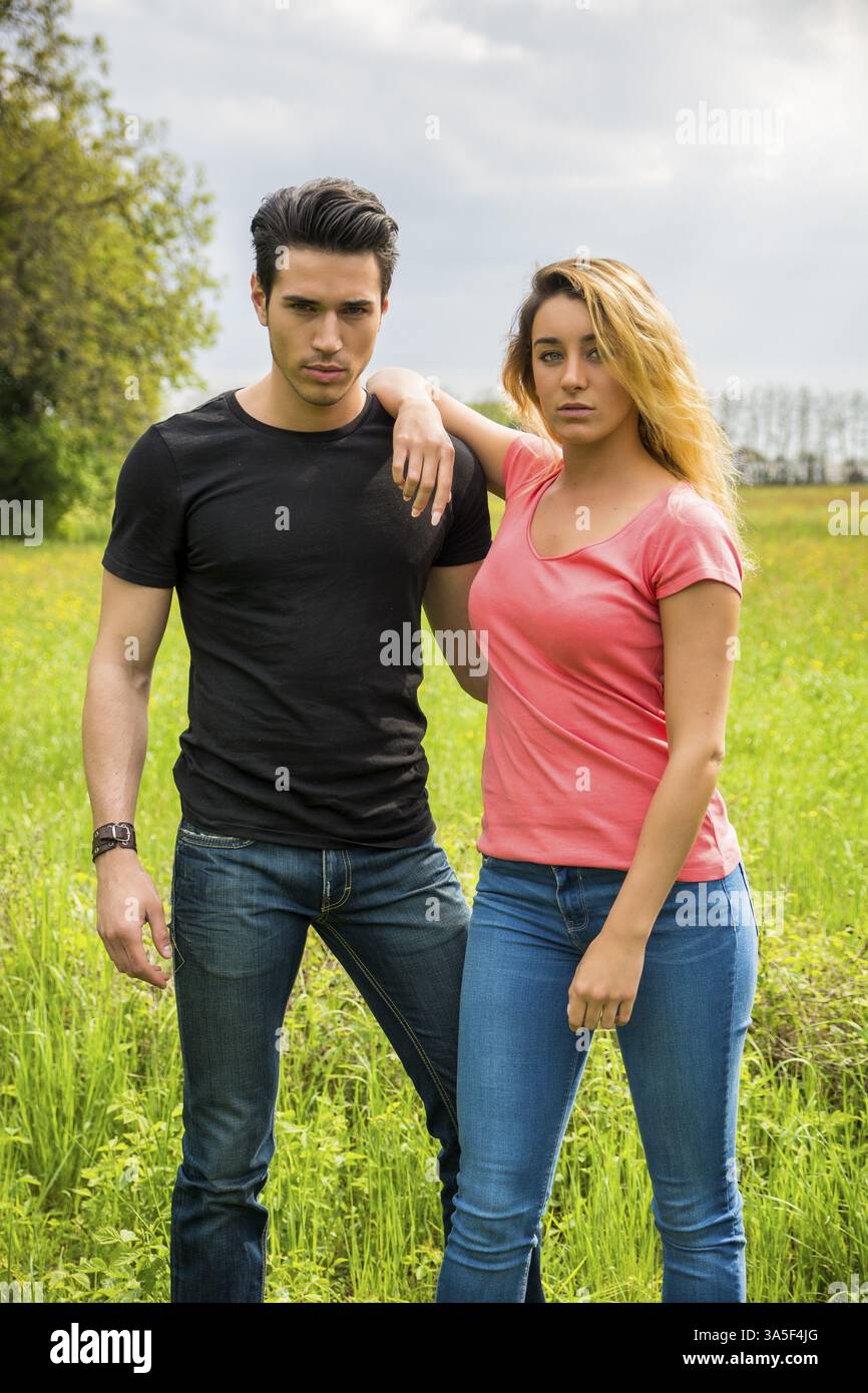 Boyfriend and girlfriend standing in countryside in green luscious ...