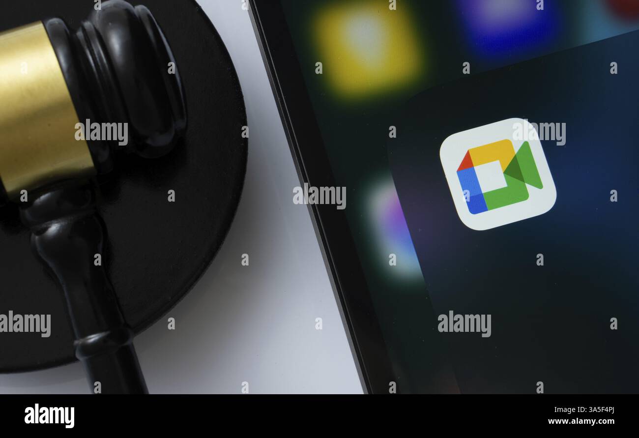 A close up of an iPad screen displaying the google meet app alongside a judge's gavel Stock ...