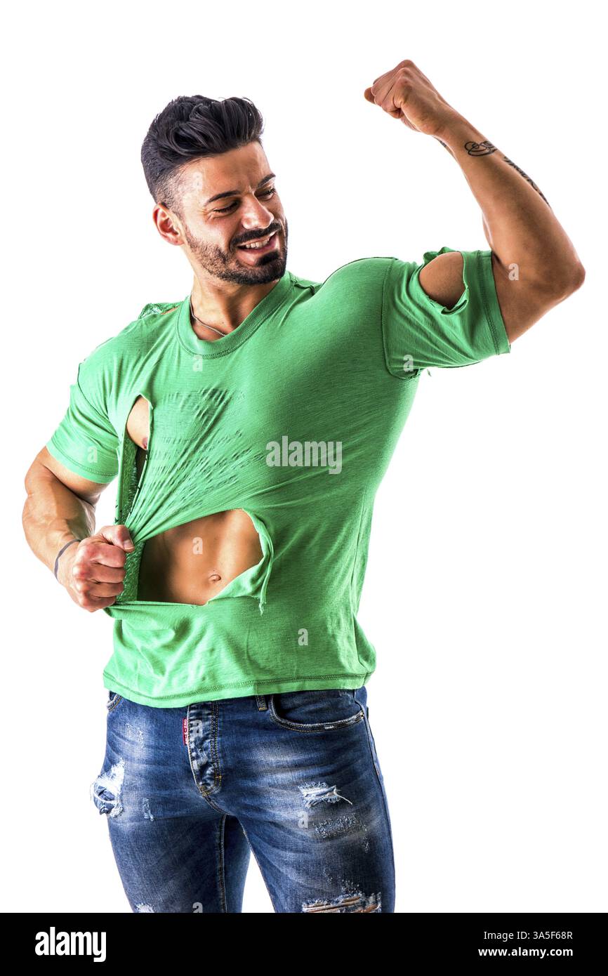 Young handsome male in jeans and torn t-shirt showing bicep and smiling ...