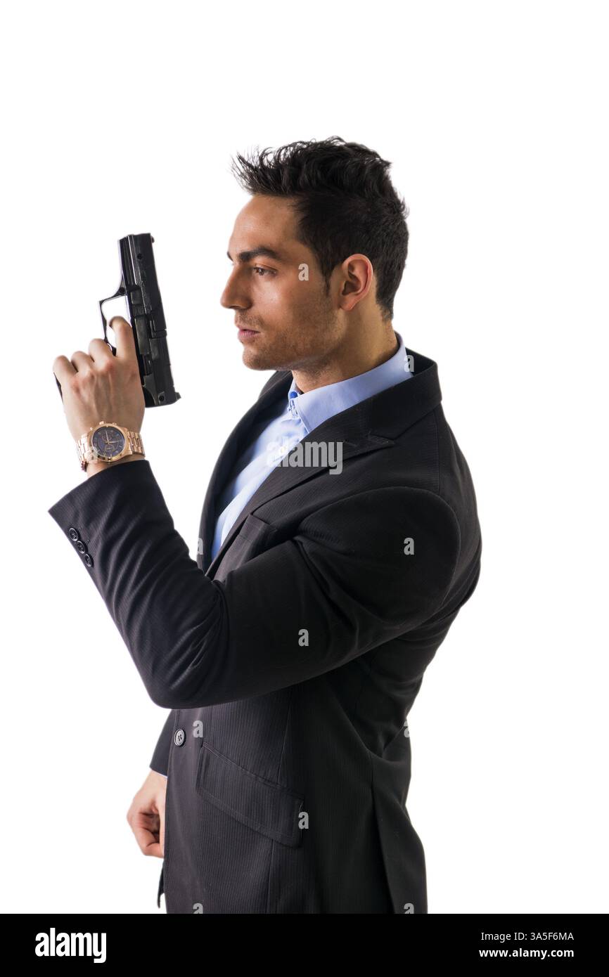 Elegant man with gun, dressed as a spy or secret agent, isolated on ...